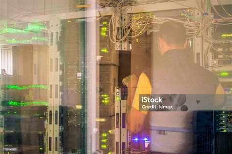 의무에 엔지니어 서버 룸의 유리 벽 뒤에 전문은 데이터 센터에서 작동합니다 남자 서버 랙에 컴퓨터 장비를 유지 관리합니다 서비스 현대 기술 플랫폼입니다 관리자에 대한 스톡