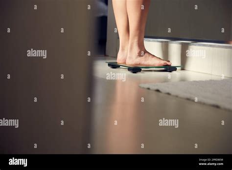 Time To Find Out The Results An Unrecognizble Woman Weighing Herself On A Scale At Home Stock