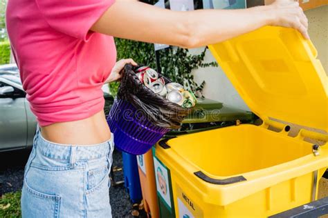 A Young Beautiful Girl Throws Sorted Garbage Into Special Bins Stock
