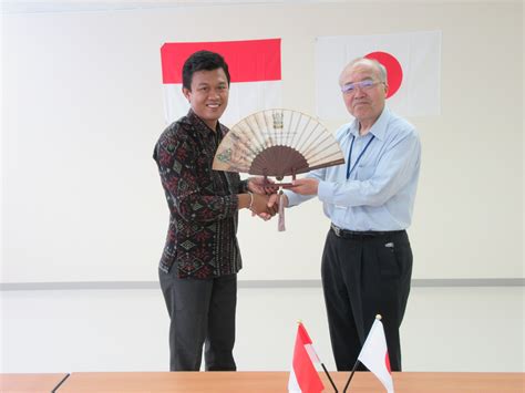 握手で扇を受け渡す両学長