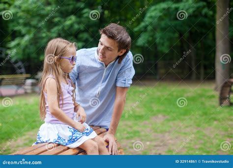 Young Father With His Cute Daughter Sitting On The Stock Image Image
