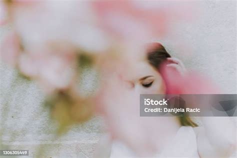 부드러운 배경에 서있는 사랑스러운 여자는 꽃을 꽃 장미 부드러운 미소 미소 화려한 젊은 소녀 여성 의 장미 꽃잎 에 에 이 핑크 배경 빗나간 포커스에 대한 스톡 사진 및