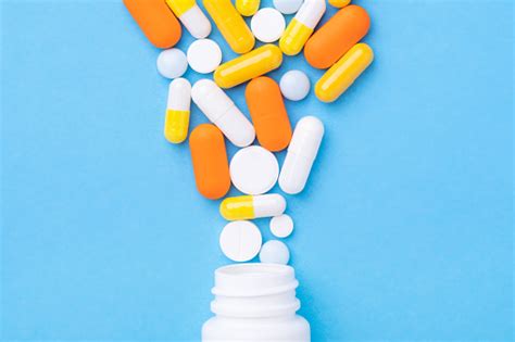 파란색 배경 클로즈업에 플라스틱 병에서 멀티 컬러 정제와 알약 캡슐 0명에 대한 스톡 사진 및 기타 이미지 0명 개념