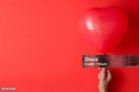 손을 들고 붉은 종이 바탕에 빨간색 하트 풍선 발렌타인의 날 또는 생일 축 하 개념 풍선에 대한 스톡 사진 및 기타 이미지