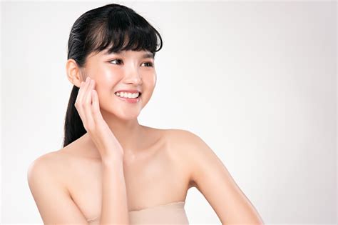 깨끗 하고 신선한 피부와 함께 부드러운 뺨과 미소를 만지는 아름 다운 젊은 아시아 여자 행복과 쾌활한 흰색 배경에 고립 아름다움과 화장품 개념 건강관리와 의술에 대한 스톡