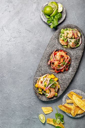 Ceviche 망고 아보카도 토마토와 세 가지 화려한 새우 세비체 라틴 아메리카 멕시코 페루 에콰도르 음식입니다 화이트 와인과 바나나 칩과 함께 제공 아보카도에 대한 스톡