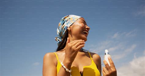 노란색 수영복을 입은 여성이 자외선 차단제 한 병을 들고 있다 사진 Unsplash의 선스크린 이미지