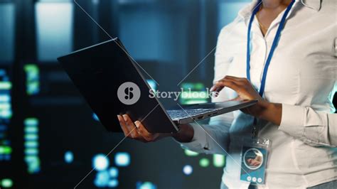 Employee Strolling Through Data Center Hardware Clusters Providing Processing Resources For