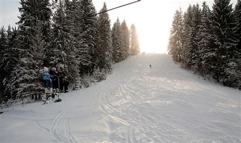사람들은 카 르 파 티아 산맥에서 리프트에 상승 에 숲과 스키 슬로프의 배경 닫습니다 겨울 자연입니다 무거운 눈이 내린다 사이드 뷰입니다 그리고 아래를 내려다 보면서입니다