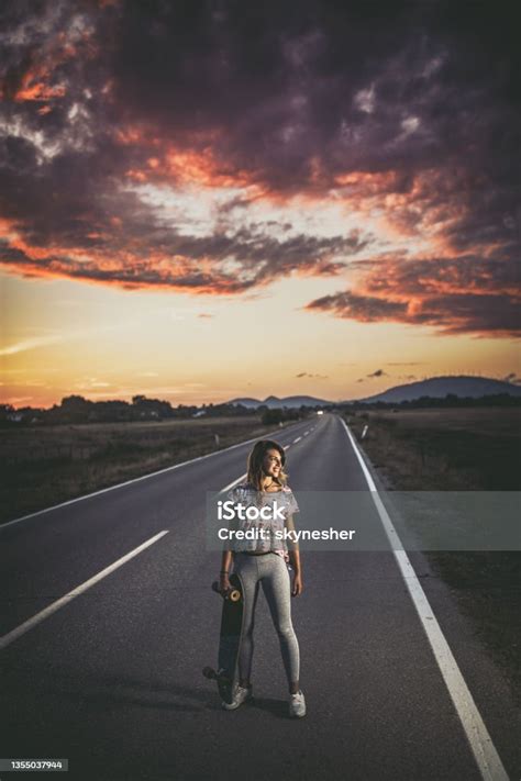 황혼의 도로에 스케이트 보드와 행복한 여자의 전체 길이 건강한 생활방식에 대한 스톡 사진 및 기타 이미지 건강한 생활방식 구름 풍경 구름이 짙게 낀 하늘 Istock