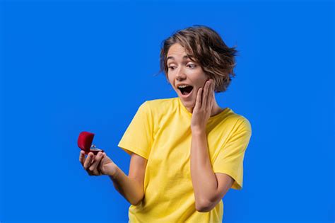 예쁜 여자는 파란 벽 배경에 제안 다이아몬드 반지가 있는 보석 상자를 얻었다 25 29세에 대한 스톡 사진 및 기타 이미지 25 29세 감정 경외감 Istock