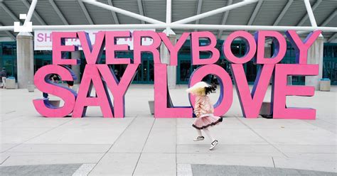 한 소녀가 모두가 사랑을 말한다는 표지판 앞에서 달리고 있습니다 사진 Unsplash의 무료 소녀 이미지