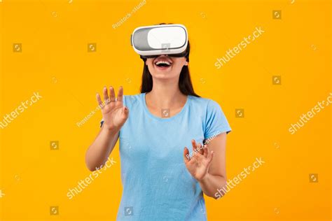 Excited Young Woman In Vr Headset Touching Air During Virtual Reality
