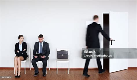 면접 대기 Formalwear에 심각한 비즈니스 사람들 문과 오는 사무실 방의 자에 앉아 인터뷰를 위해 준비 하 고 다른 후보 동안 여 Defocused 남자 걱정하는에