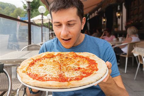 피자 가게에서 갓 구운 맛있는 마가리타와 뜨거운 피자를 먹는 행복한 청년 정통 이탈리아 요리를 제공하는 카페와 레스토랑 남자에 대한 스톡 사진 및 기타 이미지 Istock