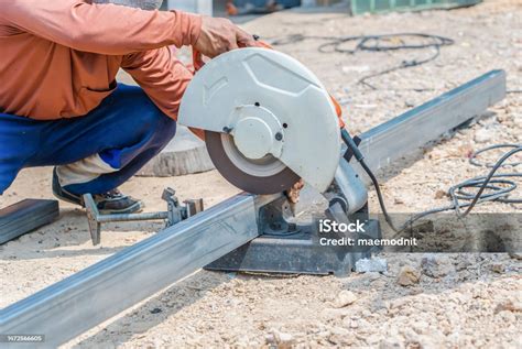 작업장에서 철제 절단기를 사용하는 남자의 손 불꽃으로 철 캐노피 프레임을 고정합니다 전기 철 절단기로 강철을 절단하는 작업자 밝은 불꽃으로 철 파이프를 절단하는 강철 절단기