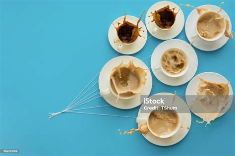Hand Holding Coffee Cups With Milk And Without In Shape Of Balloons On
