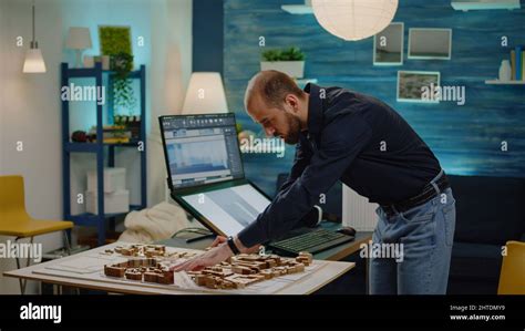 Man With Architect Job Working On Building Model With Touch Screen Computer And Maquette For