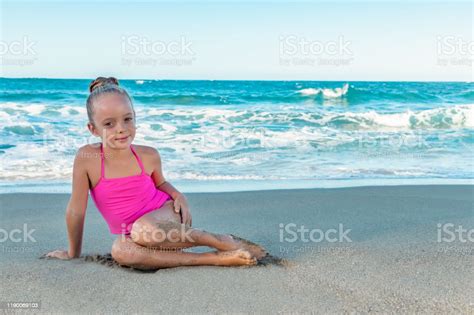 모래에 앉아 화려한 분홍색 수영복에 장난 귀여운 어린 소녀 해변에 파도 바다 배경 복사 공간 아이에 대한 스톡 사진 및 기타 이미지 Istock