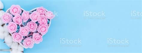 발렌타인 데이 배너입니다 하트 모양의 관에 있는 면과 분홍색 꽃의 가지 연한 파란색 배경에 분홍색과 파란색 종이 필레라 텍스트의
