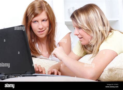 Two Girls Laying On The Sofa With Laptop Computer One Has Got A Brace