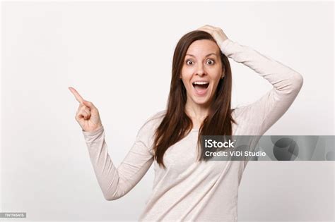 가벼운 옷을 입은 젊은 여성이 입을 열어 머리에 손을 넣어 옆에 흰색 배경에 고립 된 검지 손가락 사람들은 진심으로 감정 라이프 스타일 개념입니다 복사 공간을 모의 합니다