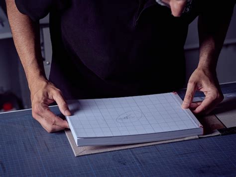 Premium Photo High Angle Of Crop Anonymous Male Worker Glue Carton Cover On Top Of Bind Book