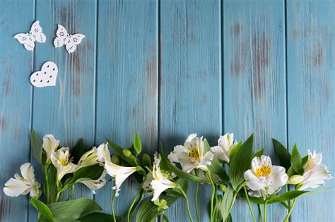 흰색 꽃과 나비와 함께 파란색 나무 배경에 텍스트 배너에 대 한 배경입니다 빈 텍스트 프레임입니다 꽃과 인사말 카드 디자인입니다 나무 배경에서 Alstroemeria 위에서