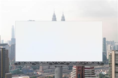 낮 시간에 Kl 도시 경관을 배경으로 하는 빈 흰색 도로 광고판 거리 광고 포스터는 3d 렌더링을 조롱합니다 전면 뷰