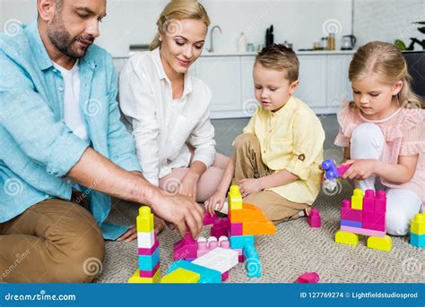 счастливые родители с милыми маленькими детьми Стоковое Фото изображение насчитывающей мама