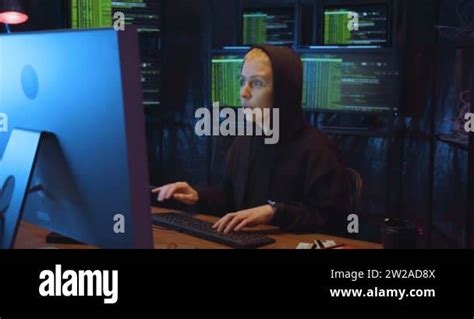 smiled woman in hood hacking programs online and success stealing data