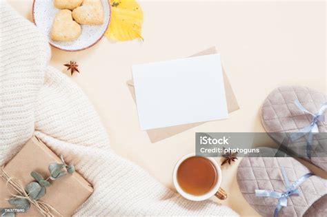 가을 플랫레이 조성물 파스텔 베이지 색 배경에 흰색 니트 격자 무늬 편지 선물 상자 슬리퍼 차 컵 낙엽과 여성스러운 바탕 화면 플랫 레이 상단 보기 가을 가을 컨셉 가정