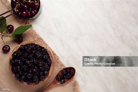 대리석 테이블에 완벽한 수제 오븐 건조 체리 잘 익은 육즙이 많은 움푹 들어간 말린 체리로 가득 찬 Wodden 접시 건조용 블랭크 평면도 평면도 텍스트를 위한 공간 가을에