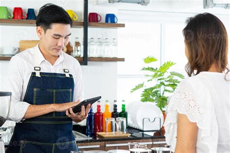 Young Barista Taking Order Of Coffee From Customer In Cafe 3154811