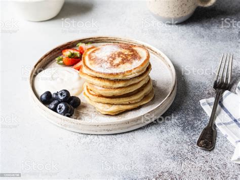 맛있는 아침 식사 과일과 딸기와 사워 크림과 함께 가루 설탕을 뿌려 스택 프리터 팬케이크 나무 테이블에 접시에 0명에 대한 스톡 사진 및 기타 이미지 Istock