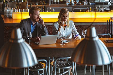 남자와 여 자가 그들의 스마트폰을 사용 하 여 고급 레스토랑에서 점심 시간 동안 테이블에 대 한 함께 앉아있는 동안 2명에 대한 스톡 사진 및 기타 이미지 Istock