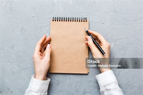 공책에 연필을 쓰고 있는 여자 손 사무실 테이블에서 일하는 여자 연필과 스케치북을 들고 있는 여성 손 모형 컨셉 단일 이미지에