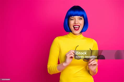 매력적인 재미 있은 여자 모던 룩 의 사진 빔 미소 깜박임 눈 홀드 레트로 사양 착용 세련된 노란색 터틀넥 블루 짧은 파란색 가발 고립 생생한 핑크 색상 배경 가발에 대한