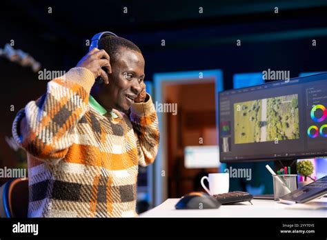 African American Videographer Works On Editing Film Footage At Home Doing Freelance Contract