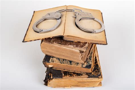 오래된 책과 금속 수갑 나쁜 말에 대한 문학과 감옥 라이트 배경 경찰관에 대한 스톡 사진 및 기타 이미지 경찰관 소송 개념 Istock