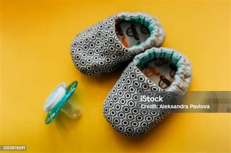 밝은 심지어 노란색 배경에 파란색 젖꼭지와 매우 작은 신생아를위한 면과 생태 직물로 만든 부드러운 슬리퍼 0명에 대한 스톡 사진 및 기타 이미지 Istock