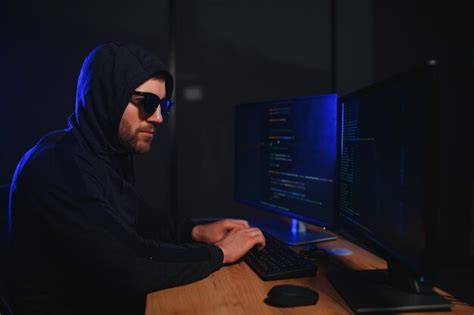 Premium Photo Hacker Sitting At Desk In Dark Atmosphere A Computer