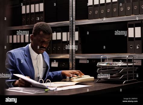 African American Inspector Answering Phone Call Discussing Investigation Evidence With Remote