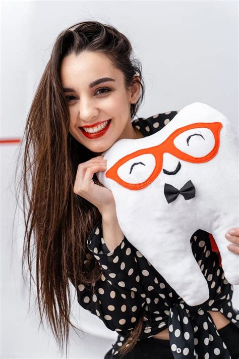 Portrait Of A Smiling Girl With Soft Toy In Hands Tooth Shaped Soft