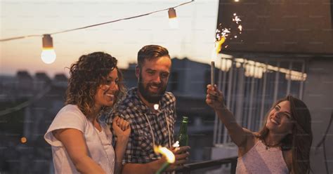 옥상 파티에서 즐거운 시간을 보내는 젊은 친구들 노래하고 춤추고 폭죽으로 손을 흔드는 사람들 사진 Unsplash의 우정 이미지