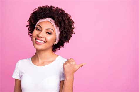 파스텔 핑크 컬러 배경에 고립 된 카피 스페이스에 엄지 손가락을 가리키는 곱슬 여자의 사진 초상화 T 셔츠에 대한 스톡 사진 및 기타 이미지 Istock