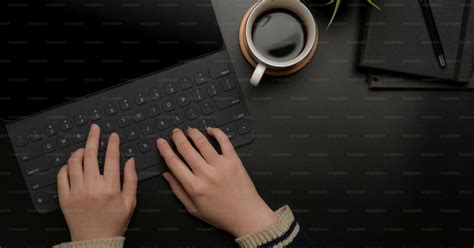 커피 컵과 일정 책이 있는 어두운 현대적인 사무실 책상에서 디지털 태블릿 키보드로 타이핑하는 손의 오버헤드 샷 사진 Unsplash의 태국 이미지