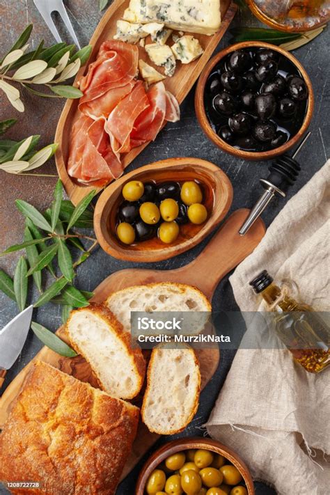 검은 색과 녹색 올리브 올리브 나무 가지 오일 치즈 도르블루 또는 고르곤졸라 프로슈토와 시아바타 빵 어두운 테이블에 맨 위 보기 플랫 레이 건강한 식생활에 대한 스톡 사진