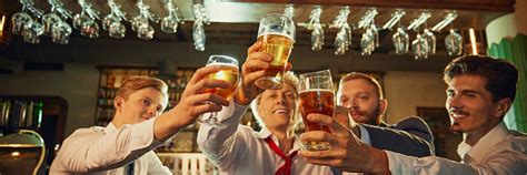 건배하며 잔을 들어 올리는 네 개의 손을 클로즈업한 사진으로 축제 분위기가 물씬 풍기는 바 환경에서 화합과 축하를 강조합니다 금요일 분위기 20 24세에 대한 스톡 사진 및