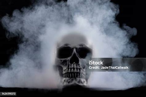 검은 배경 위에 오래된 나무 테이블에 할로윈 인간 두개골 공포 악의 치아 공포와 안개 연기로 무서운 할로윈 축제에서 죽음의 머리를위한 두개골 뼈의 모양 복사 공간 0명에